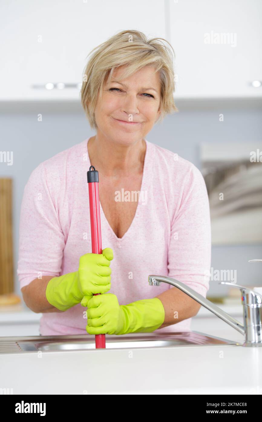senior woman unblocking a sink Stock Photo - Alamy