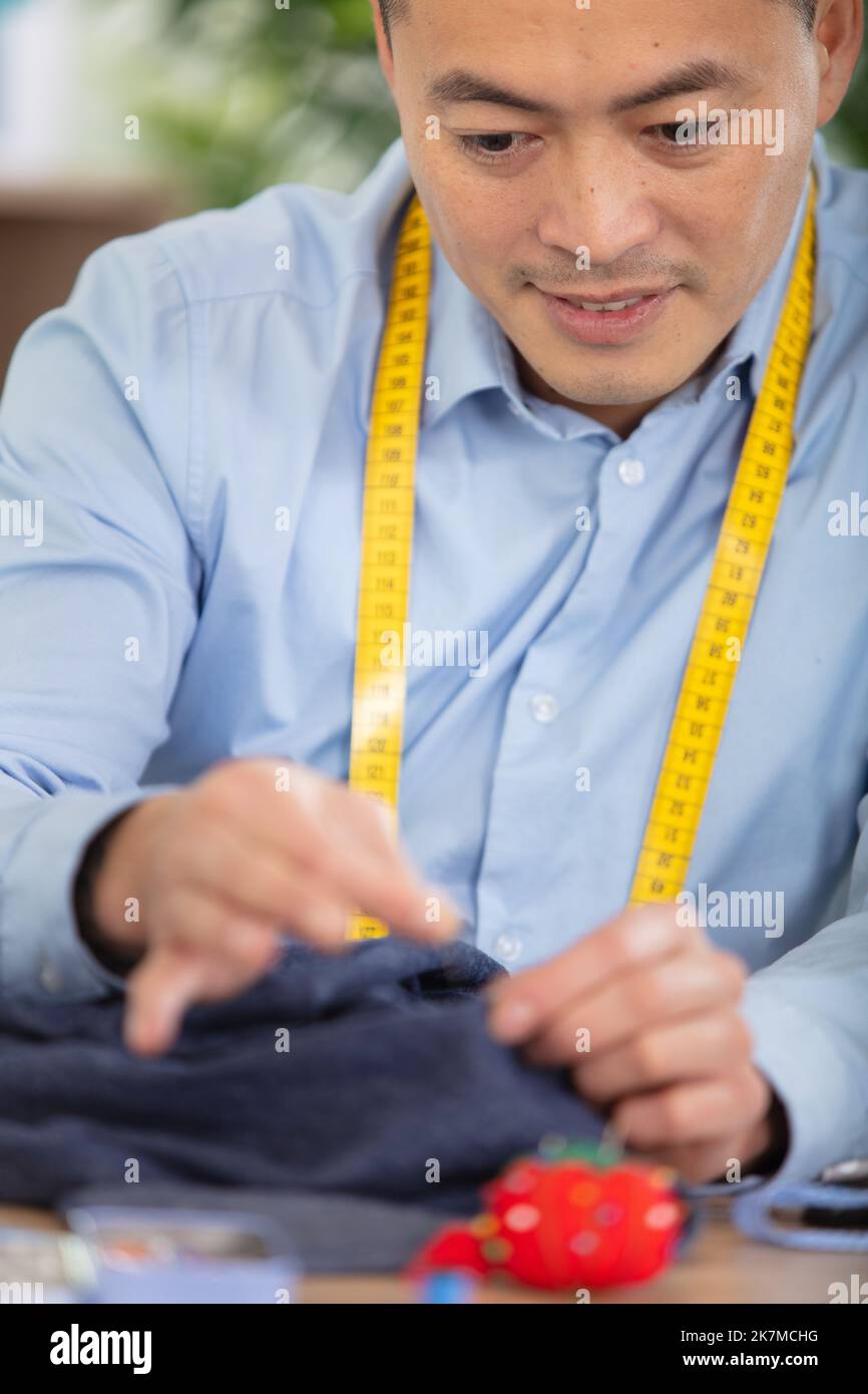 focused man seamstress sewing in workshop Stock Photo - Alamy