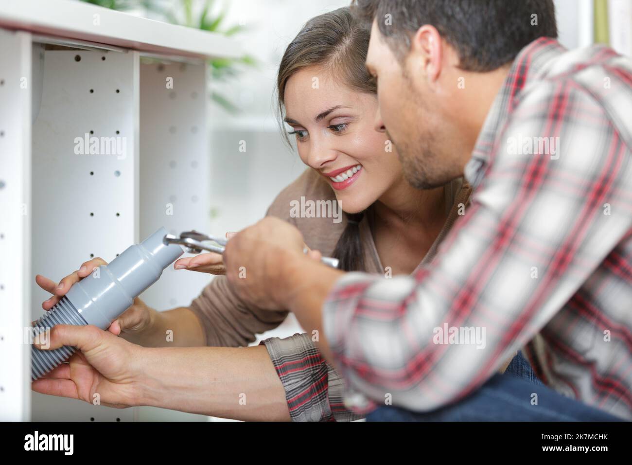 a couple fixing kitchen sink Stock Photo - Alamy