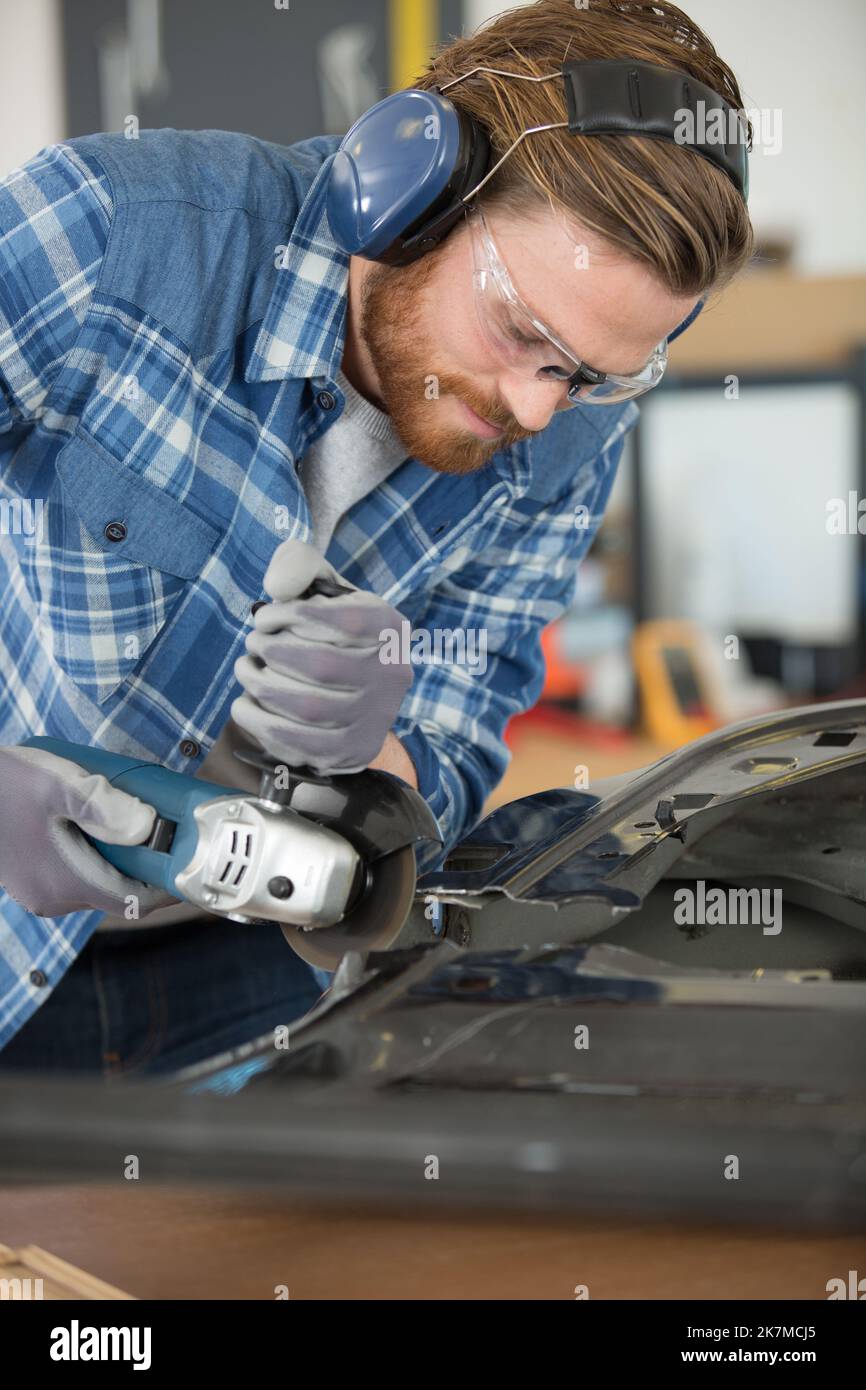 workman using an angle grinder on a car door Stock Photo - Alamy
