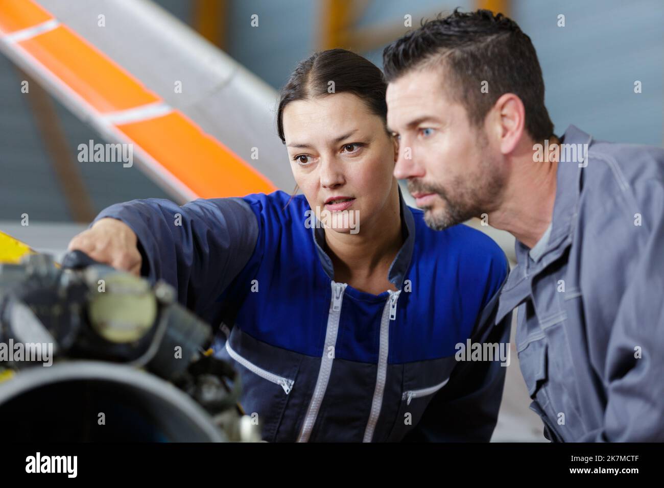 worker man and woman checking engine Stock Photo - Alamy