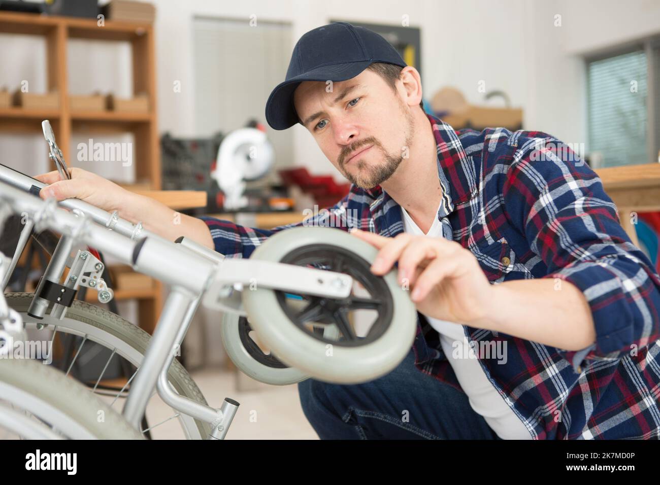 man repairing a wheelchair in workshop Stock Photo - Alamy