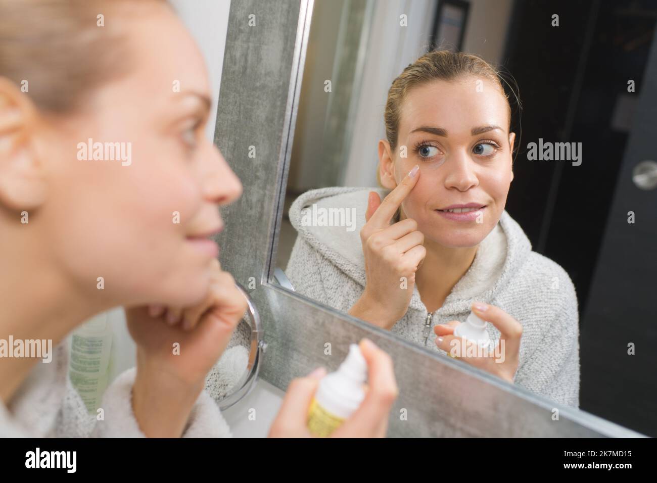 woman applying cream underneath her eye Stock Photo - Alamy