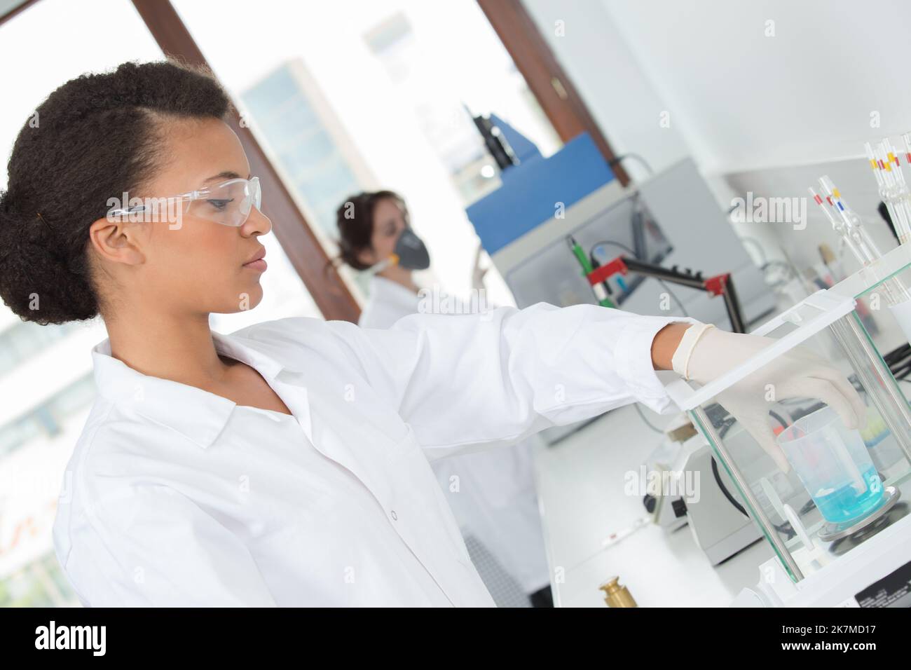Laboratory worker putting flask of liquid into machine Stock Photo - Alamy