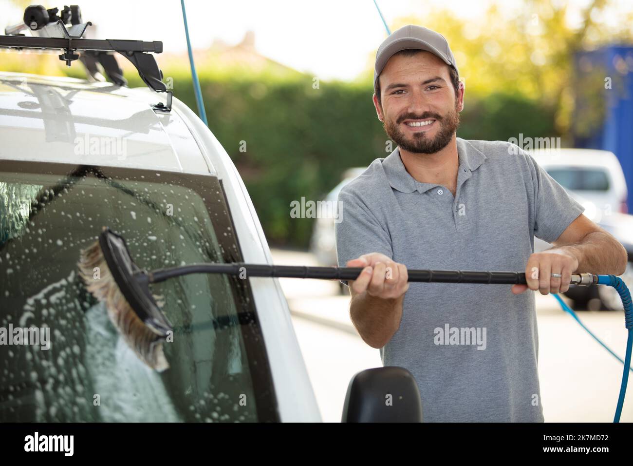 bearded employee cleaning car windscreen in a car-wash facility Stock ...
