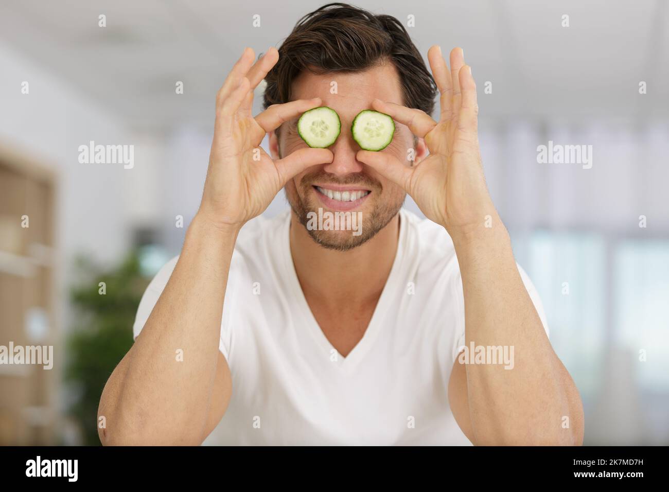 man holding fresh cucumber slices on his face Stock Photo - Alamy