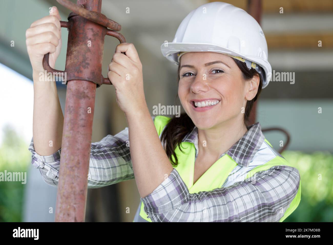 female builder tightening an acro prop Stock Photo - Alamy