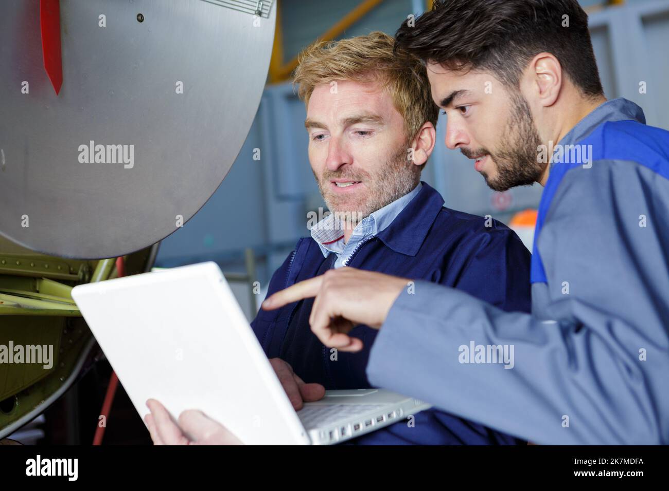 two male engineers looking at laptop computer Stock Photo - Alamy