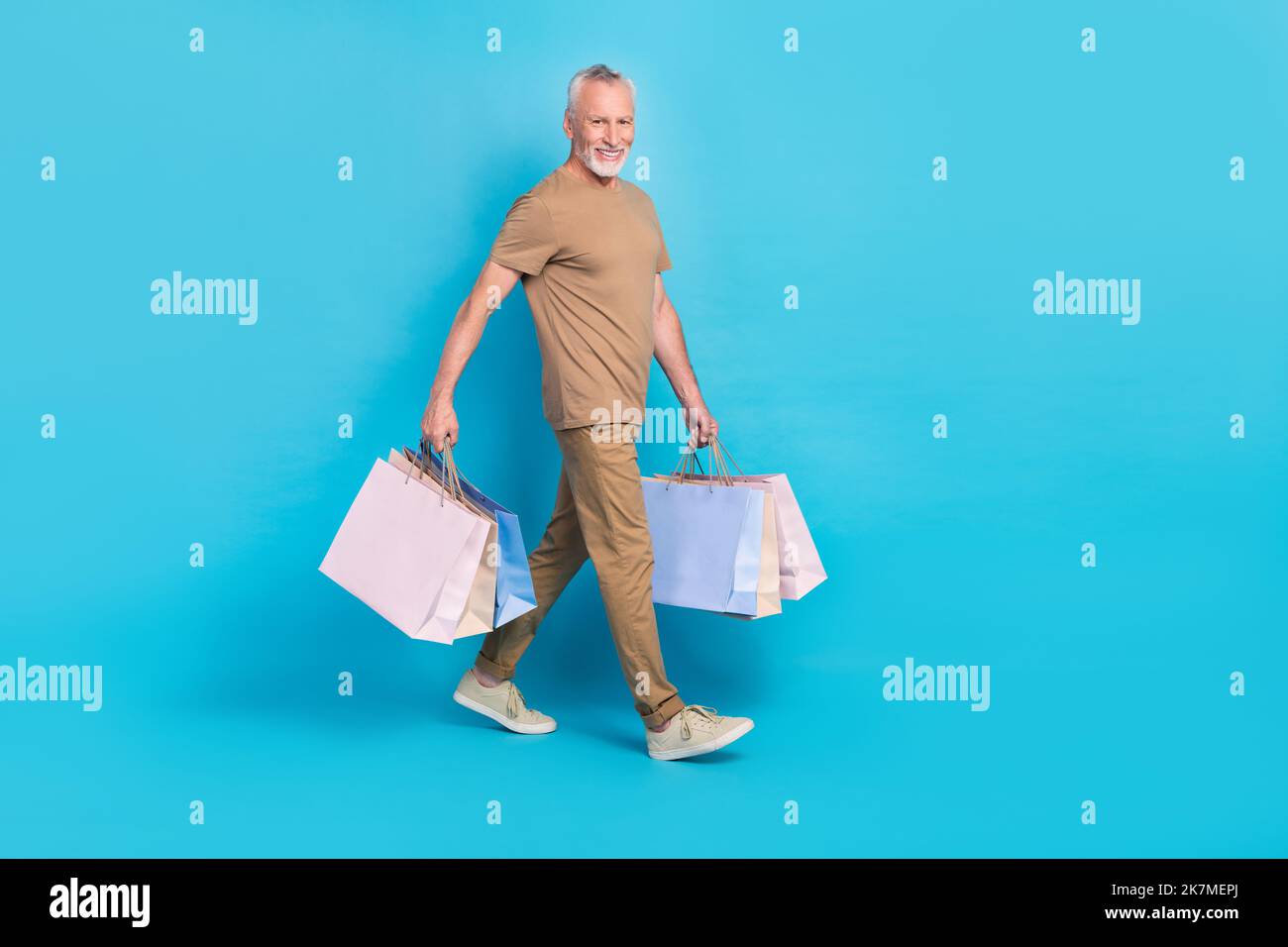 Full body profile photo of positive person hold packages walking ...