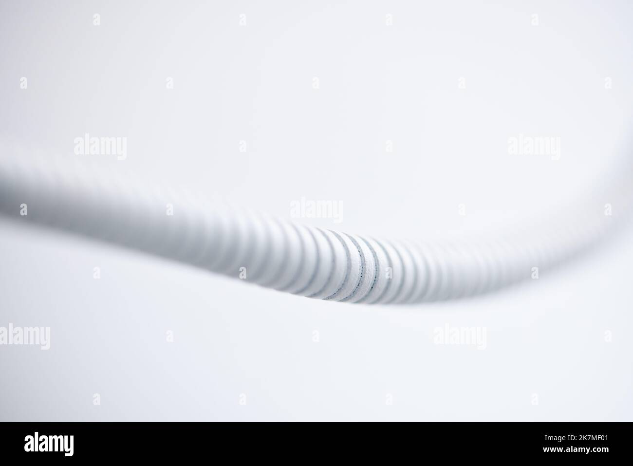 white plastic corrugated pipe on white background Stock Photo - Alamy