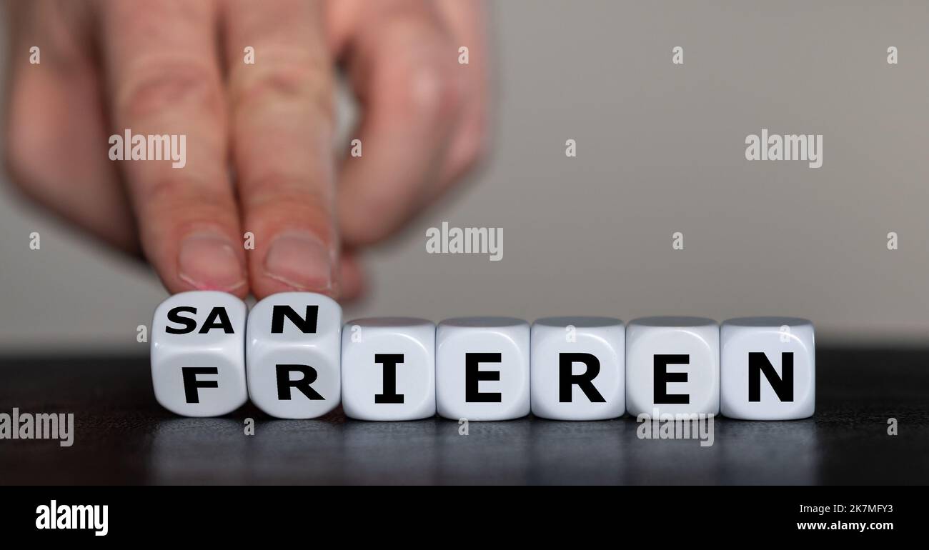 Hand turns dice and changes the German word "frieren" (to freeze) to ...