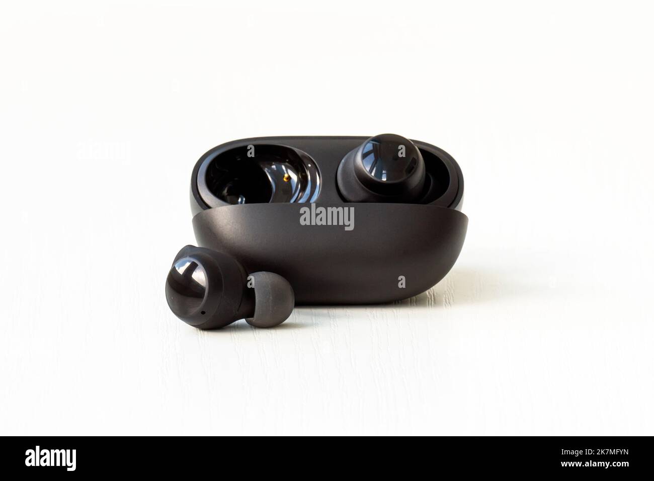 Wireless black earphones with contactless charging close-up on a white ...