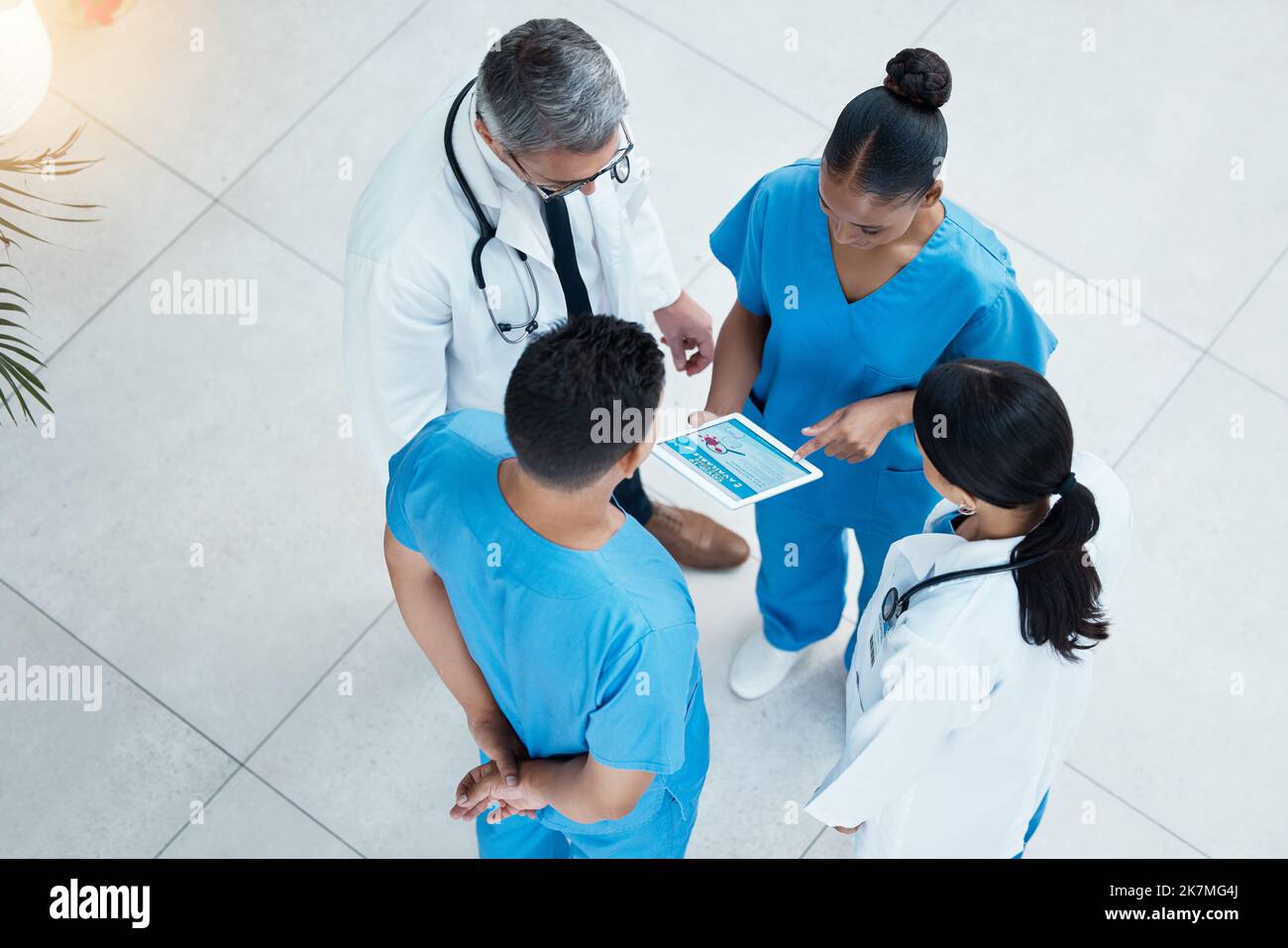 Doctor, nurse and conversation with tablet from above, medical team ...