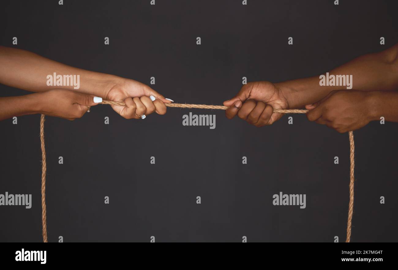Tug of war, man and woman pulling rope in opposite direction for ...