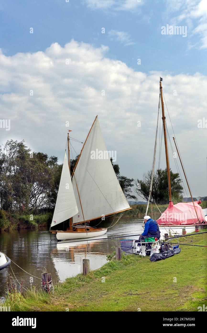 fisherman and traditional broads sailing boat on river thurne martham ...