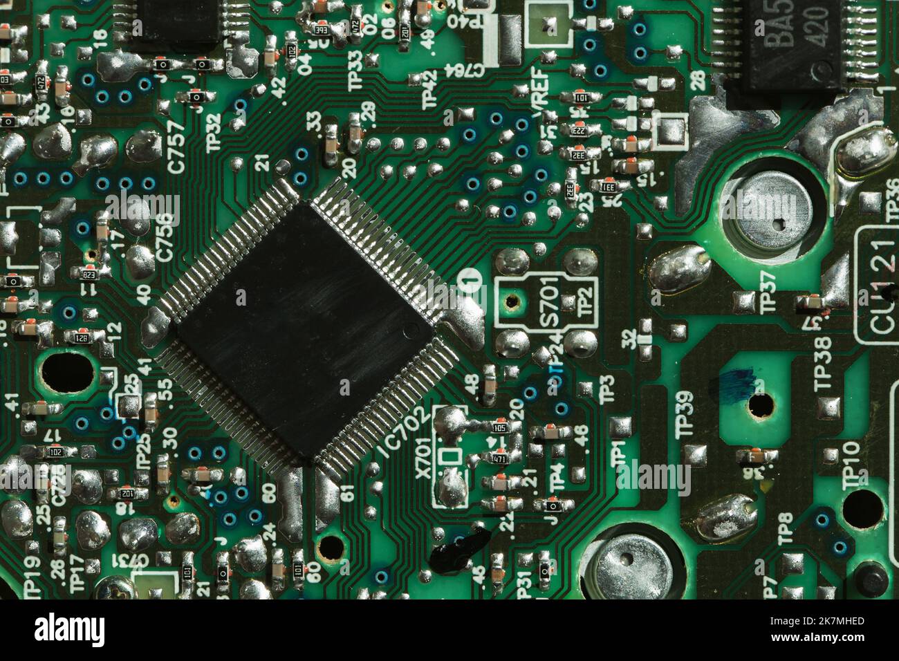 Green printed circuit top view with microchip and capacitors, close up ...