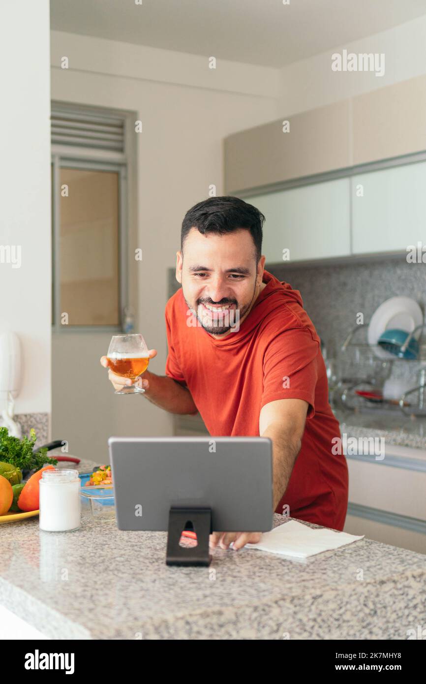 man checking a recipe online with a tablet while having a beer and ...