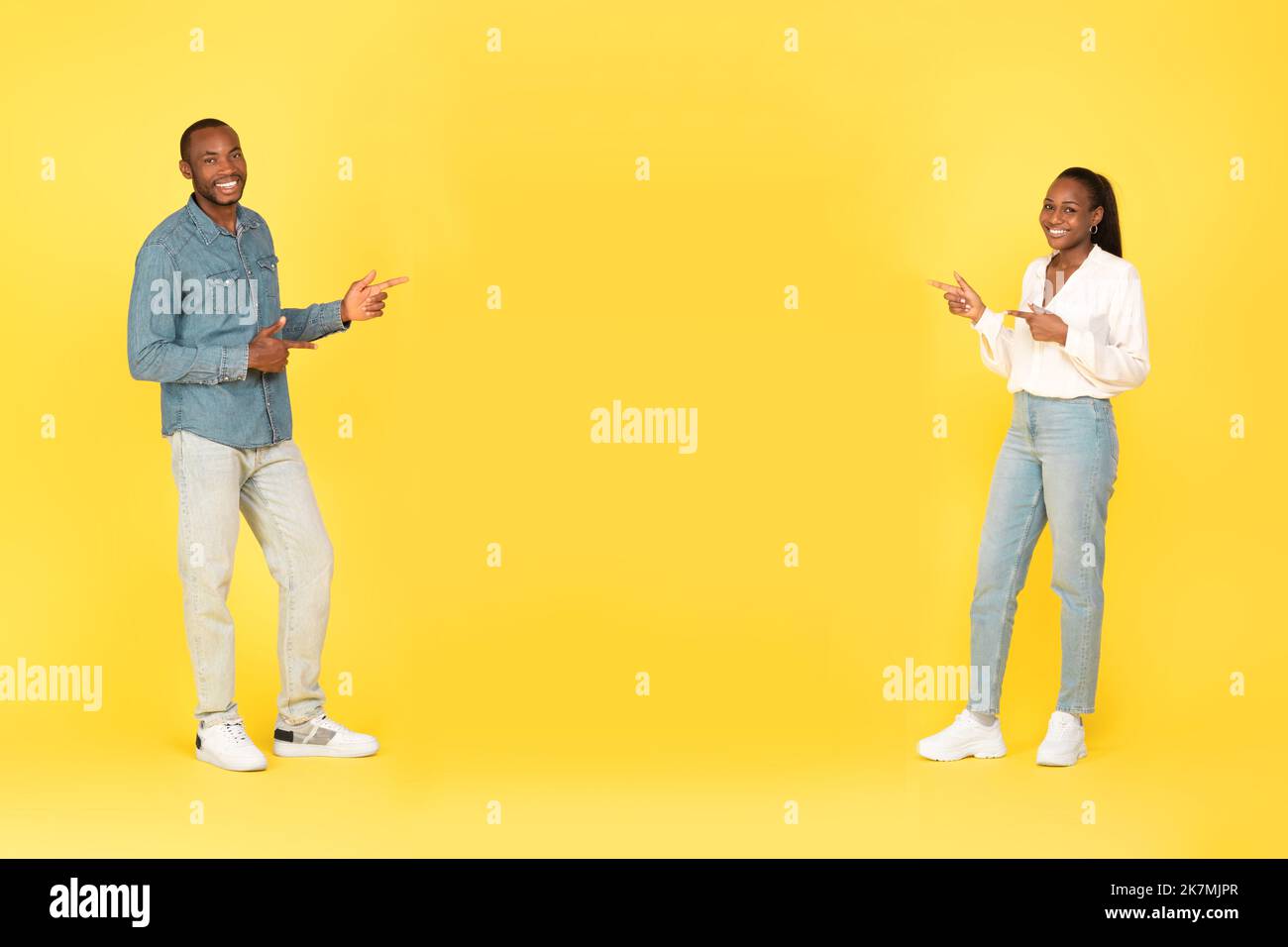 Cheerful African Spouses Pointing Fingers At Free Space, Yellow ...