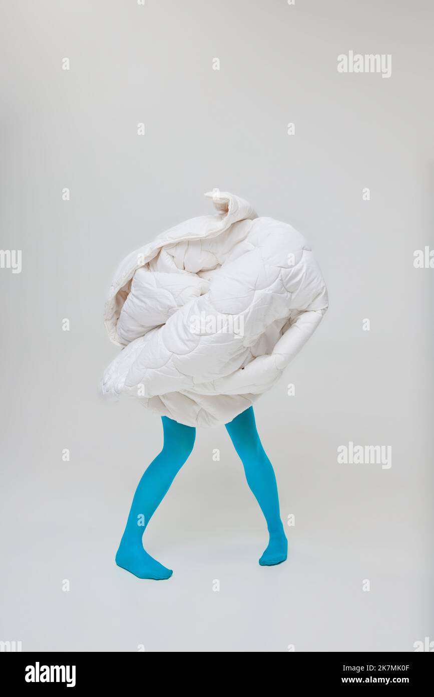 Portrait of young girl in blue tights covered in white blanket isolated ...