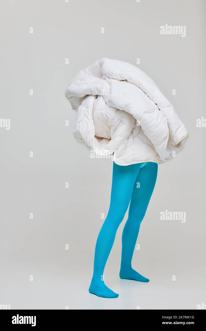 Portrait of young girl in blue tights covered in white blanket isolated ...