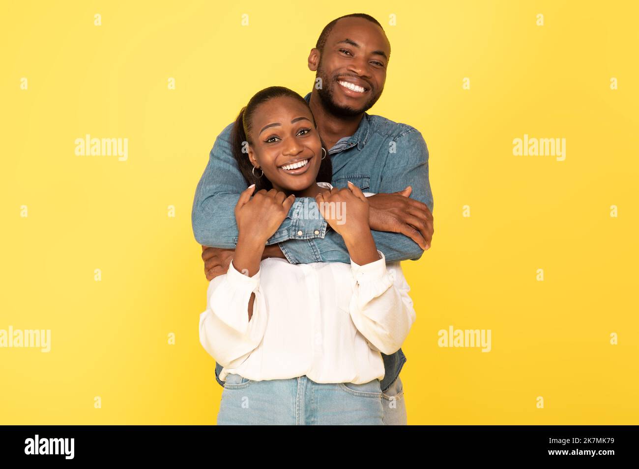 Loving African American Spouses Hugging Posing On Yellow Studio ...