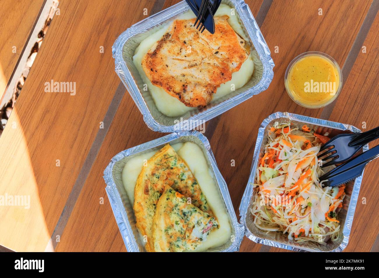 Food delivery. Different aluminium lunch box with chicken fillet ...