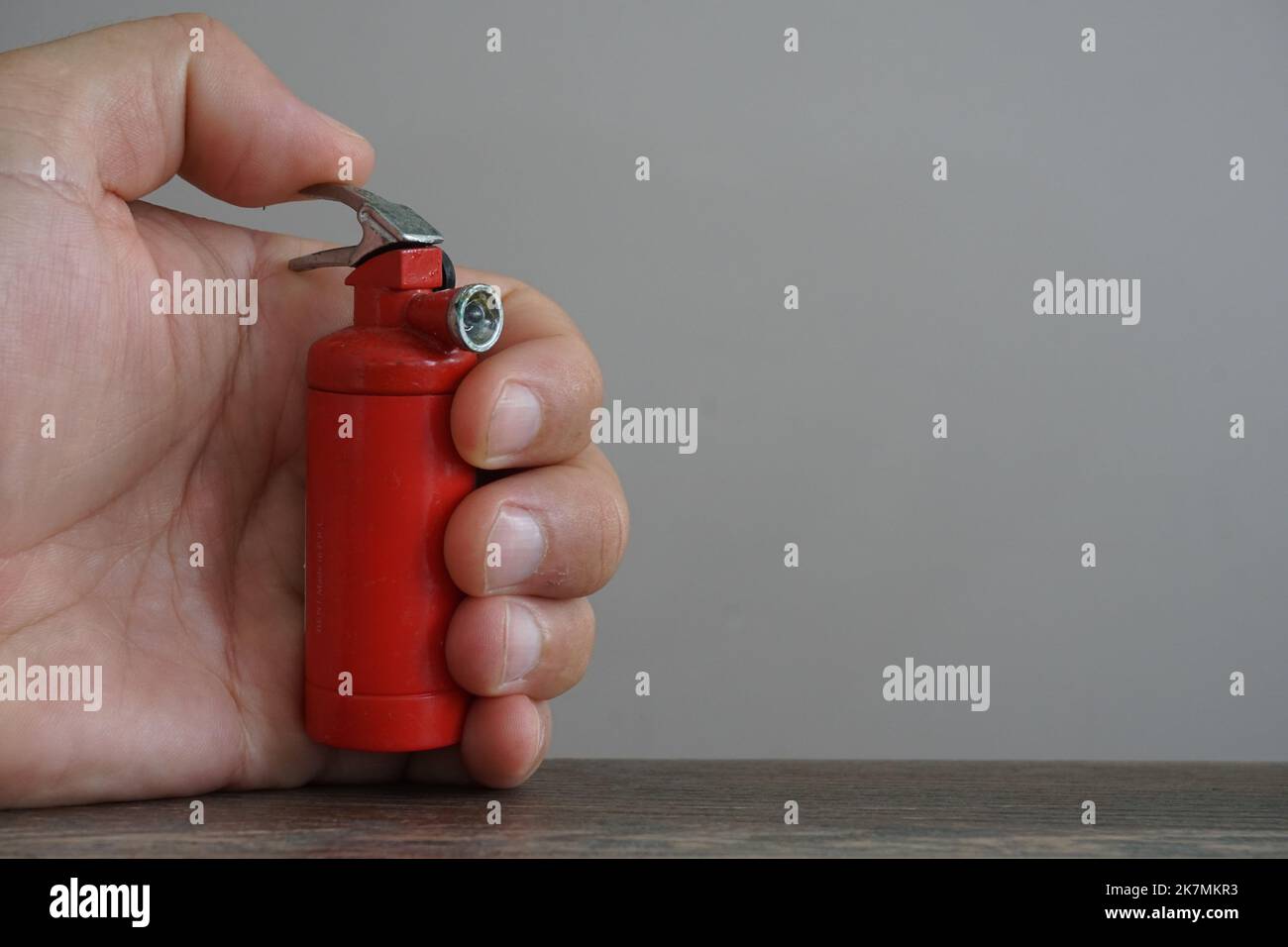 miniature fire extinguisher and man's hand Stock Photo - Alamy