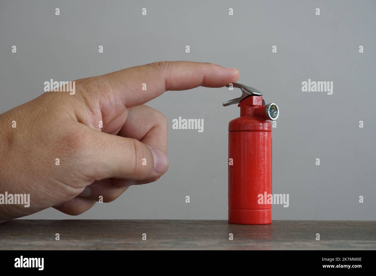 miniature fire extinguisher and man's hand Stock Photo - Alamy
