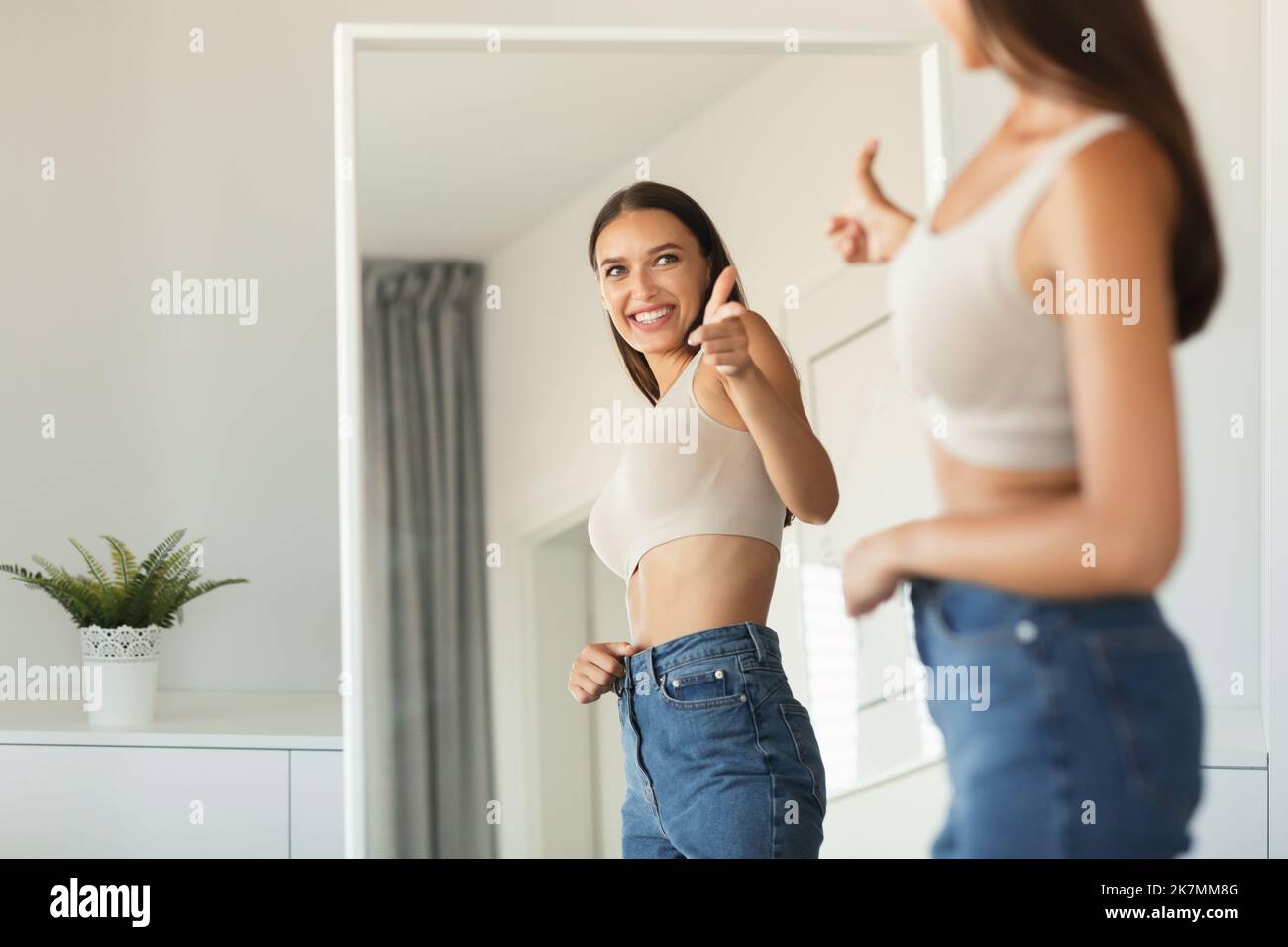 Pretty Female Pointing Finger At Her Reflection In Mirror Indoors Stock ...