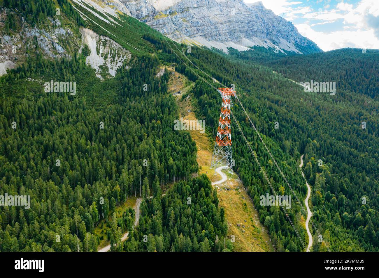 High voltage electric transmission tower in the mountains surrounded by ...