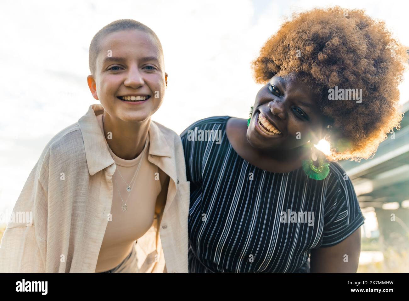 Two different woman showing off their friendship. Outdoor closeup ...