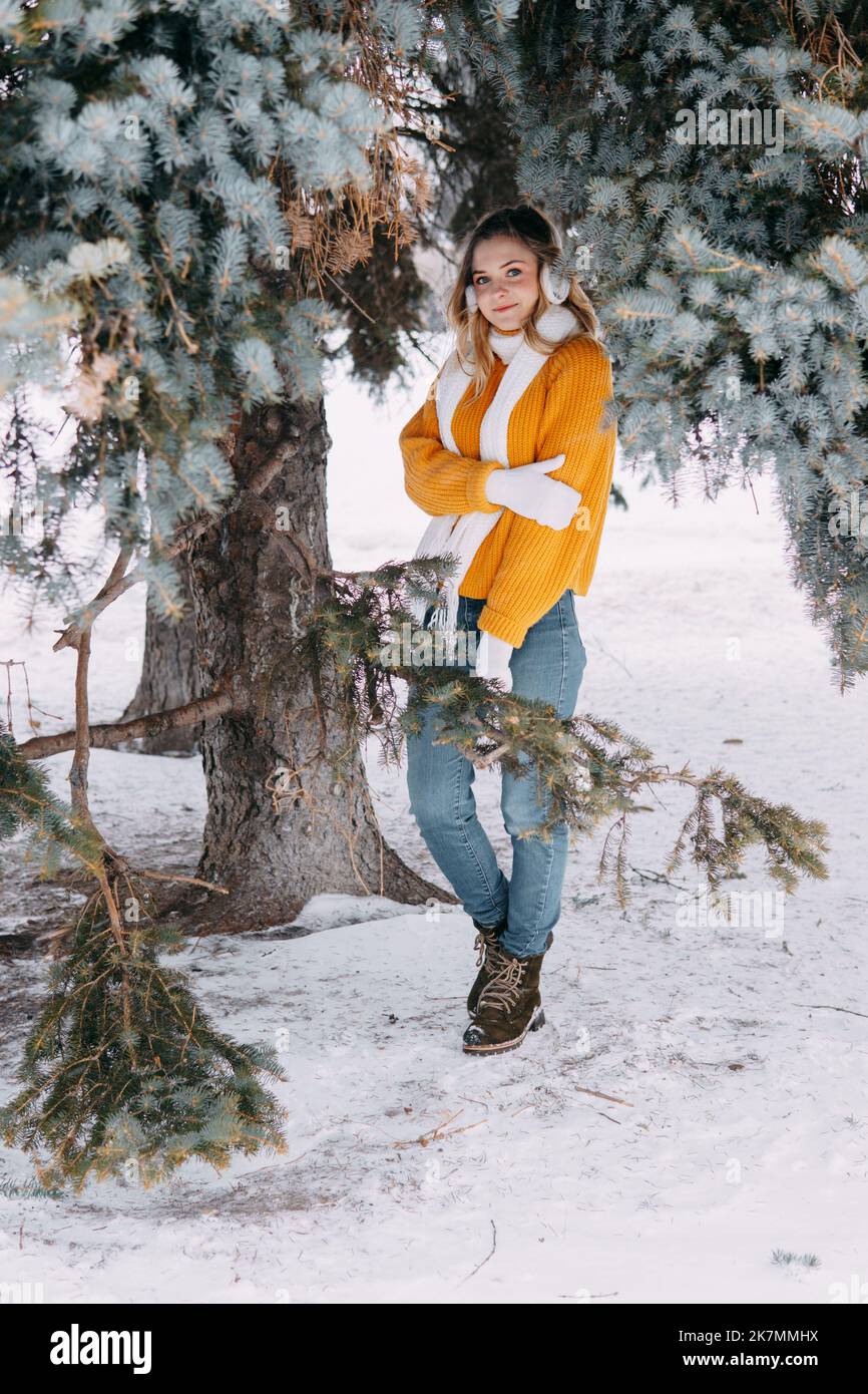 Teen blonde in a yellow sweater outside in winter. A teenage girl on a ...