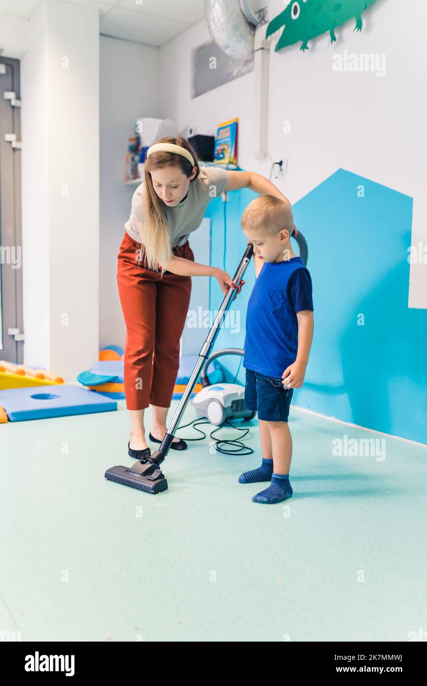 let's clean the room, my dear - Caucasian boy in blue clothes holding a ...