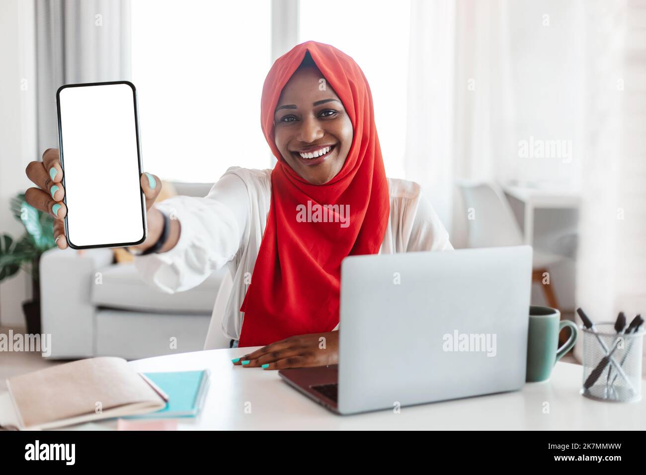 Business app. African american muslim woman showing smartphone with ...