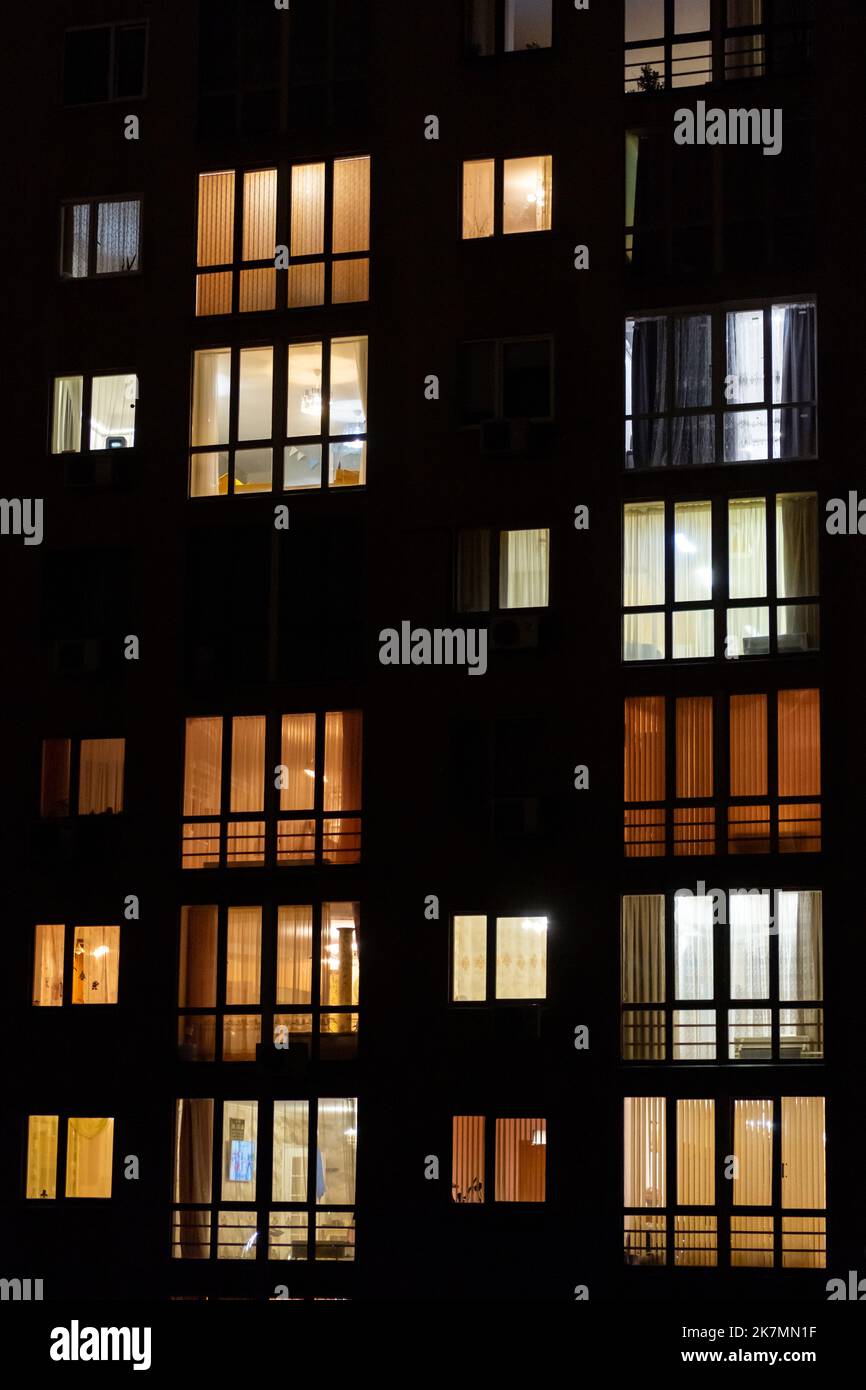 Illuminated windows of night multistory apartment building. Lighted ...