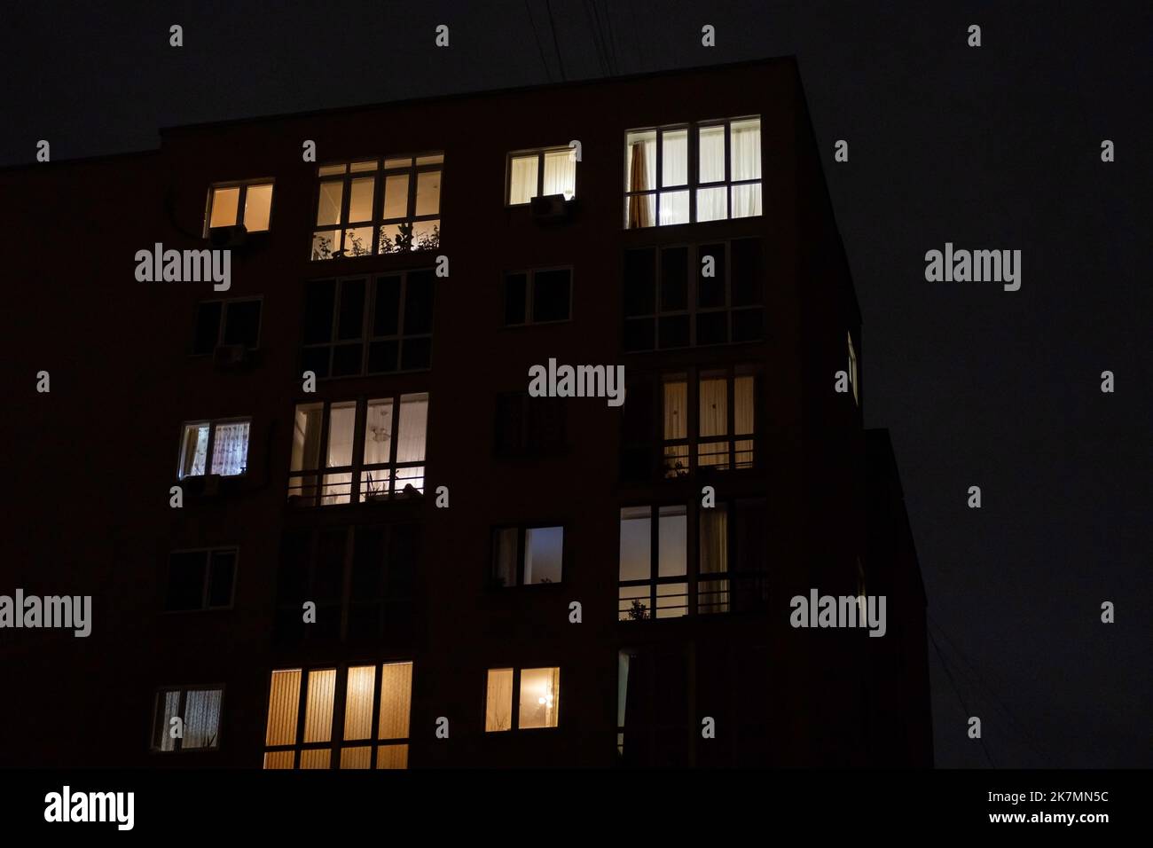 Illuminated windows of night multistory apartment building. Lighted ...