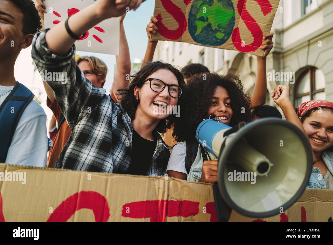 Group of happy climate activists protesting with banners and a ...
