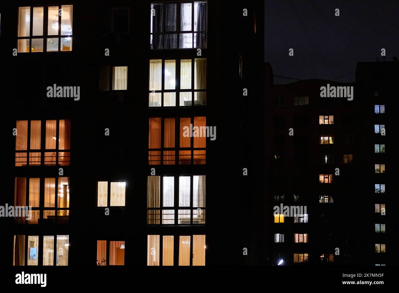 Illuminated windows of night multistory apartment building. Lighted ...