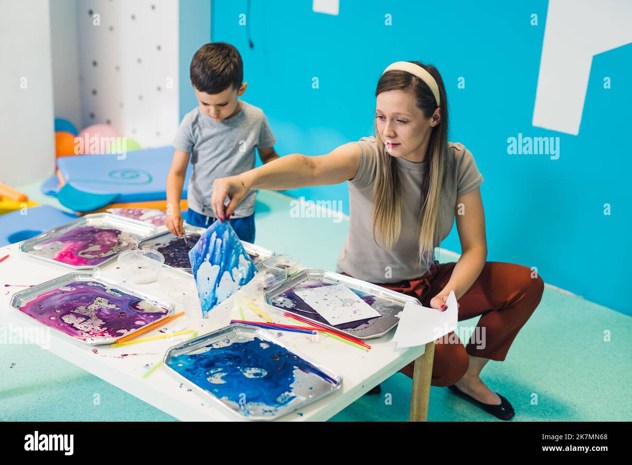 a teacher using creative techniques for painting with her kids at the ...