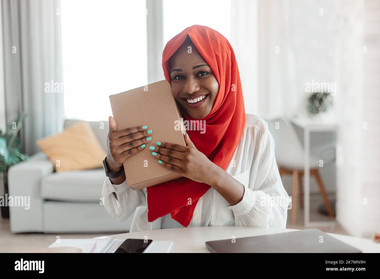 Satisfied african american muslim lady hugging cardboard box, getting ...