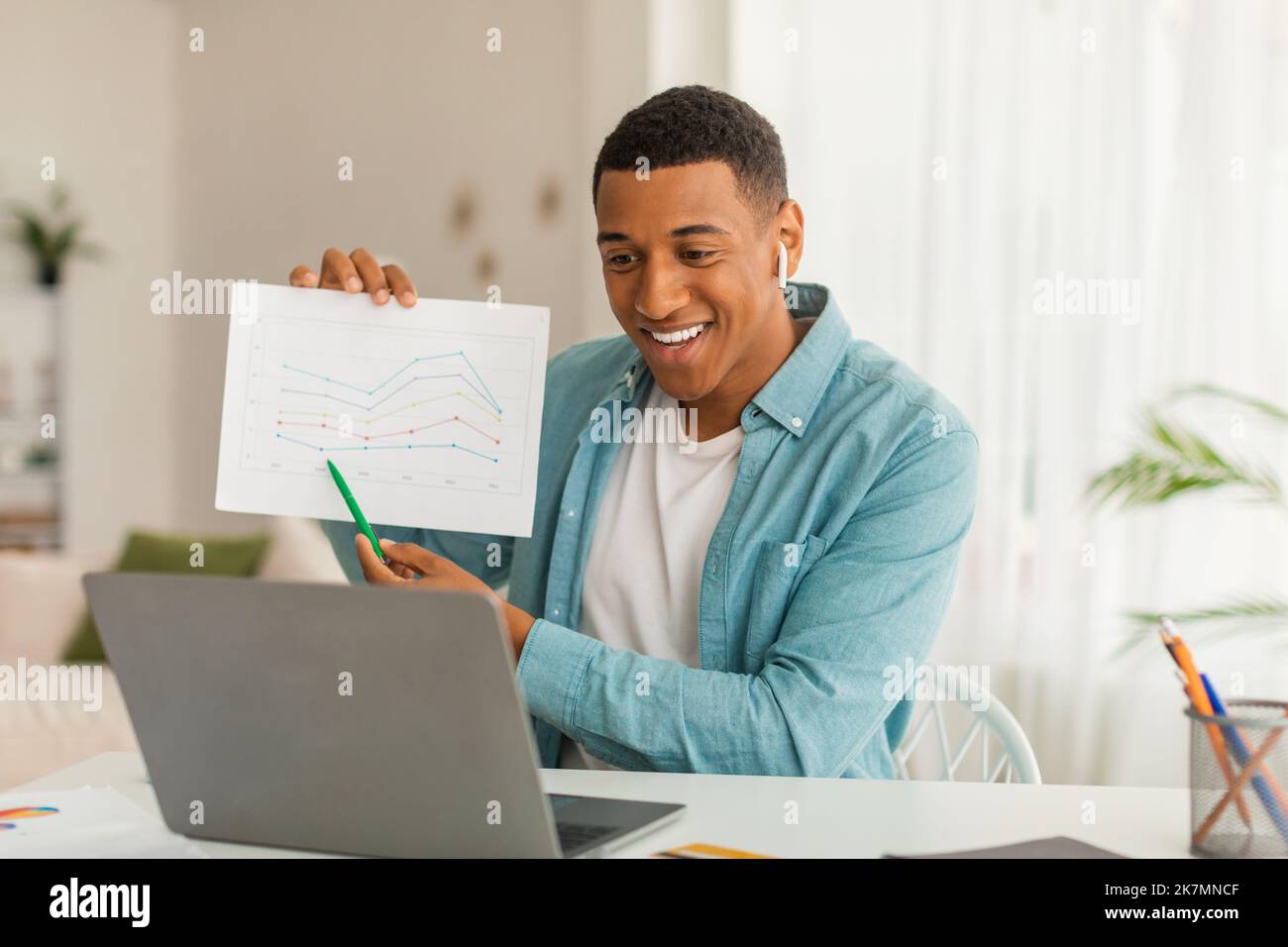 Smiling millennial african american male in wireless headphones shows ...