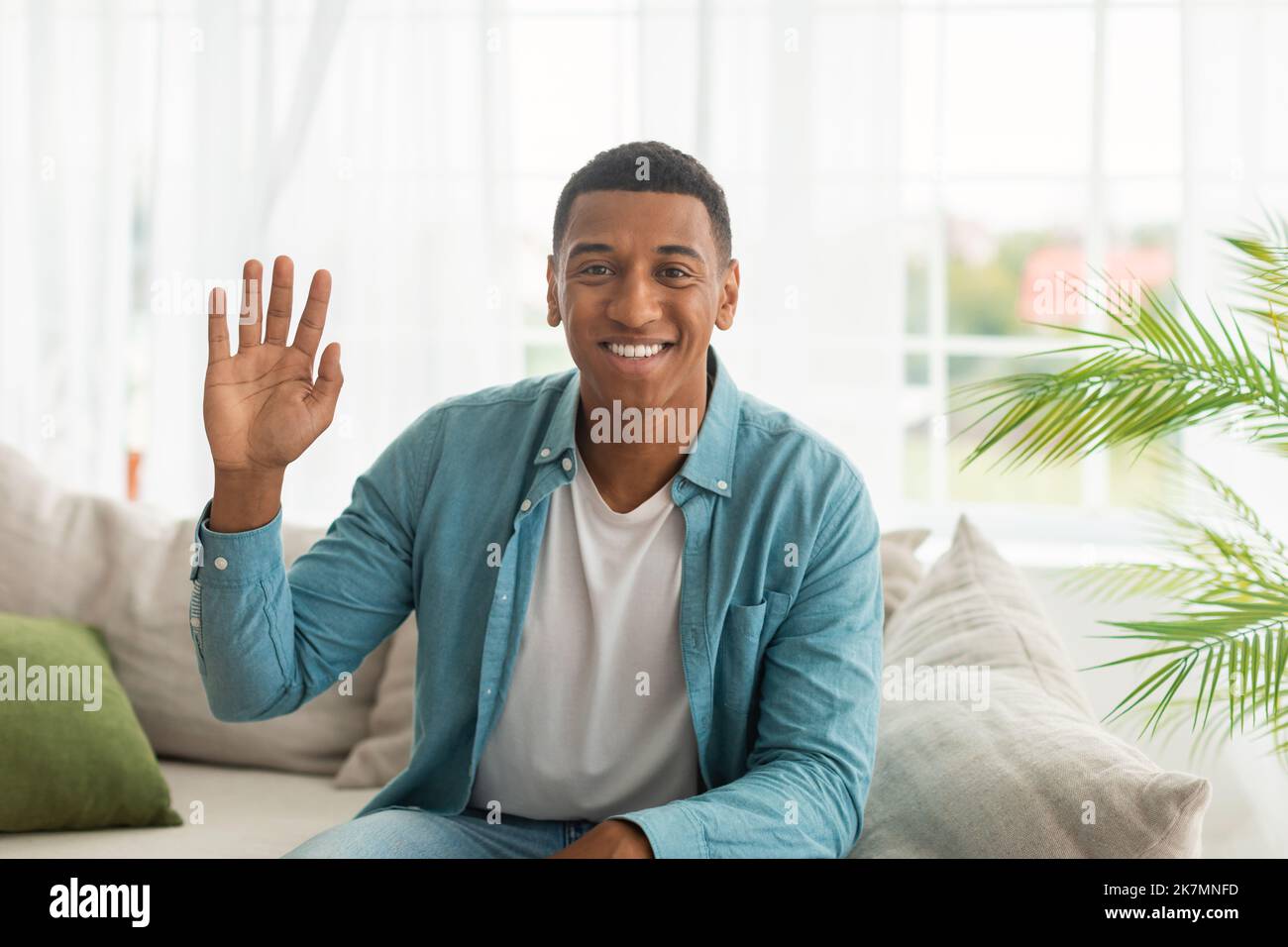 Headshot of smiling millennial african american guy waving hand, has ...