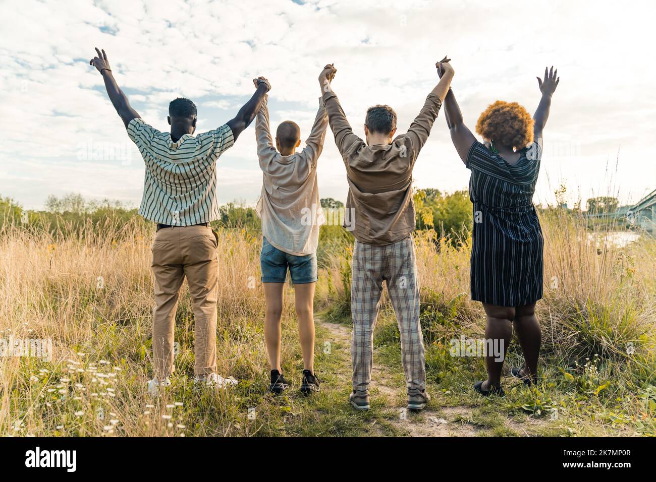 Positive group of four people of diverse ethnicities standing next to ...