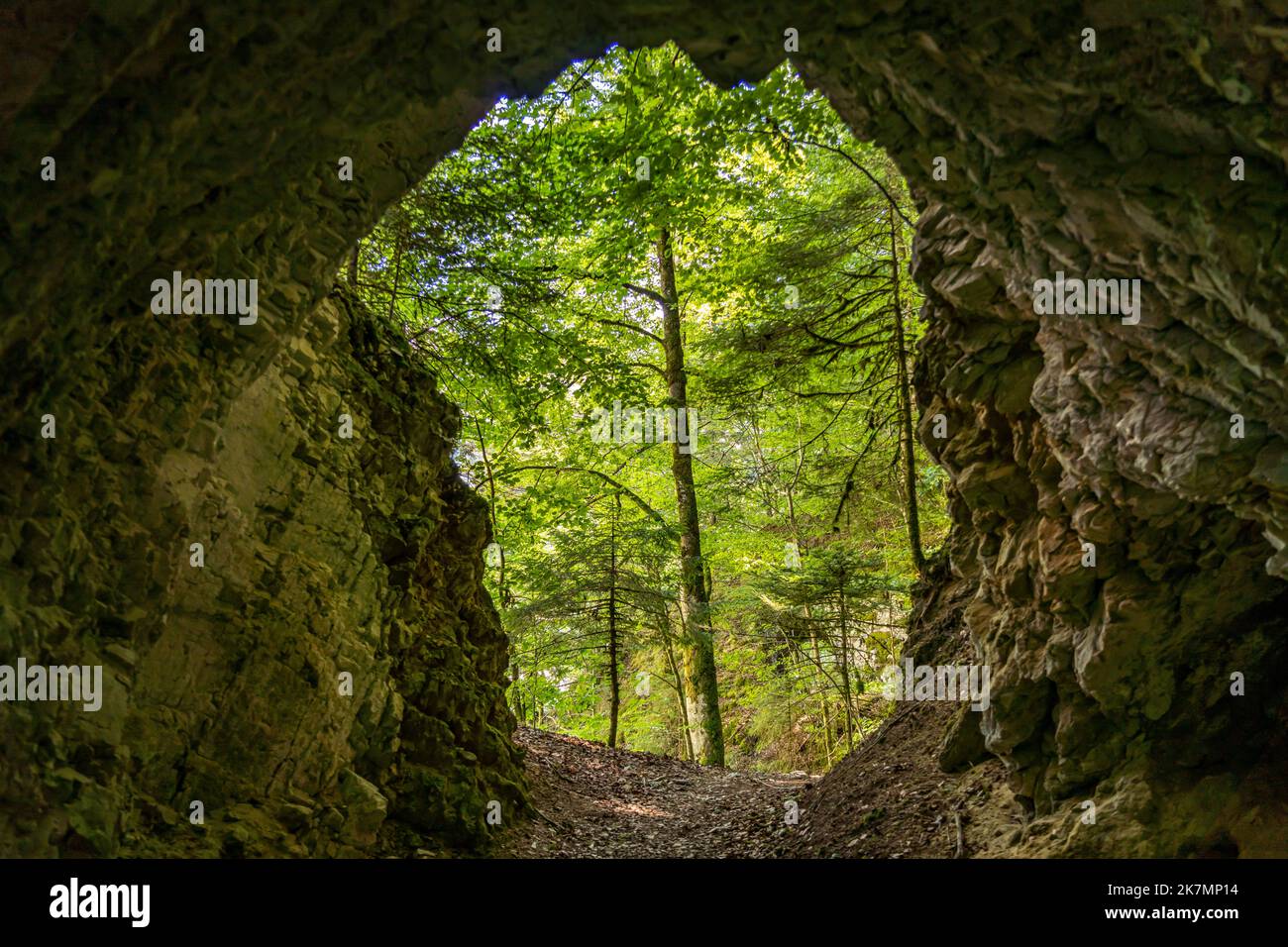 Tunnel im Felsen am Wanderweg rund um den Stausee Lac des Moron ...