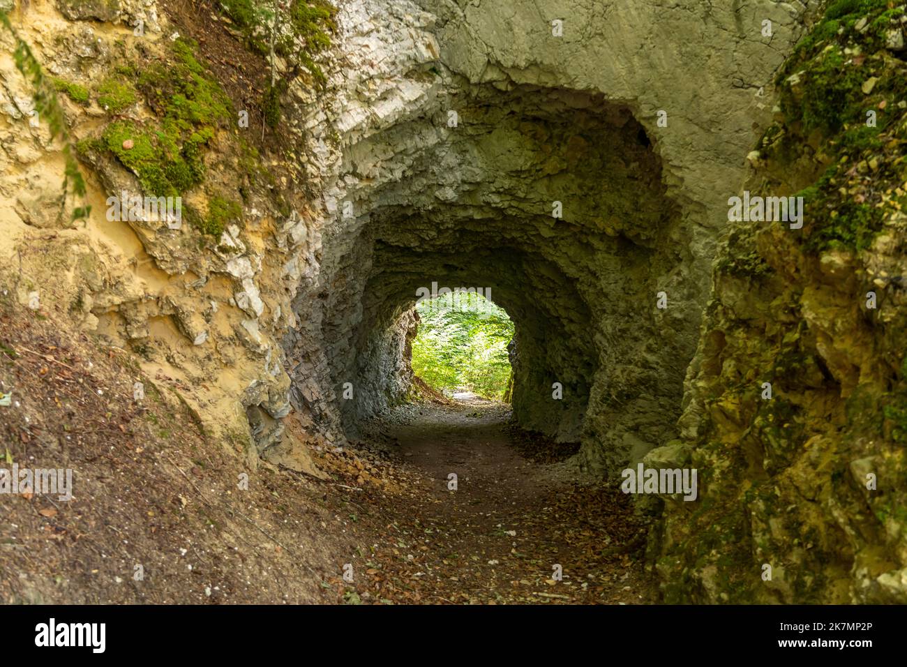 Tunnel im Felsen am Wanderweg rund um den Stausee Lac des Moron ...