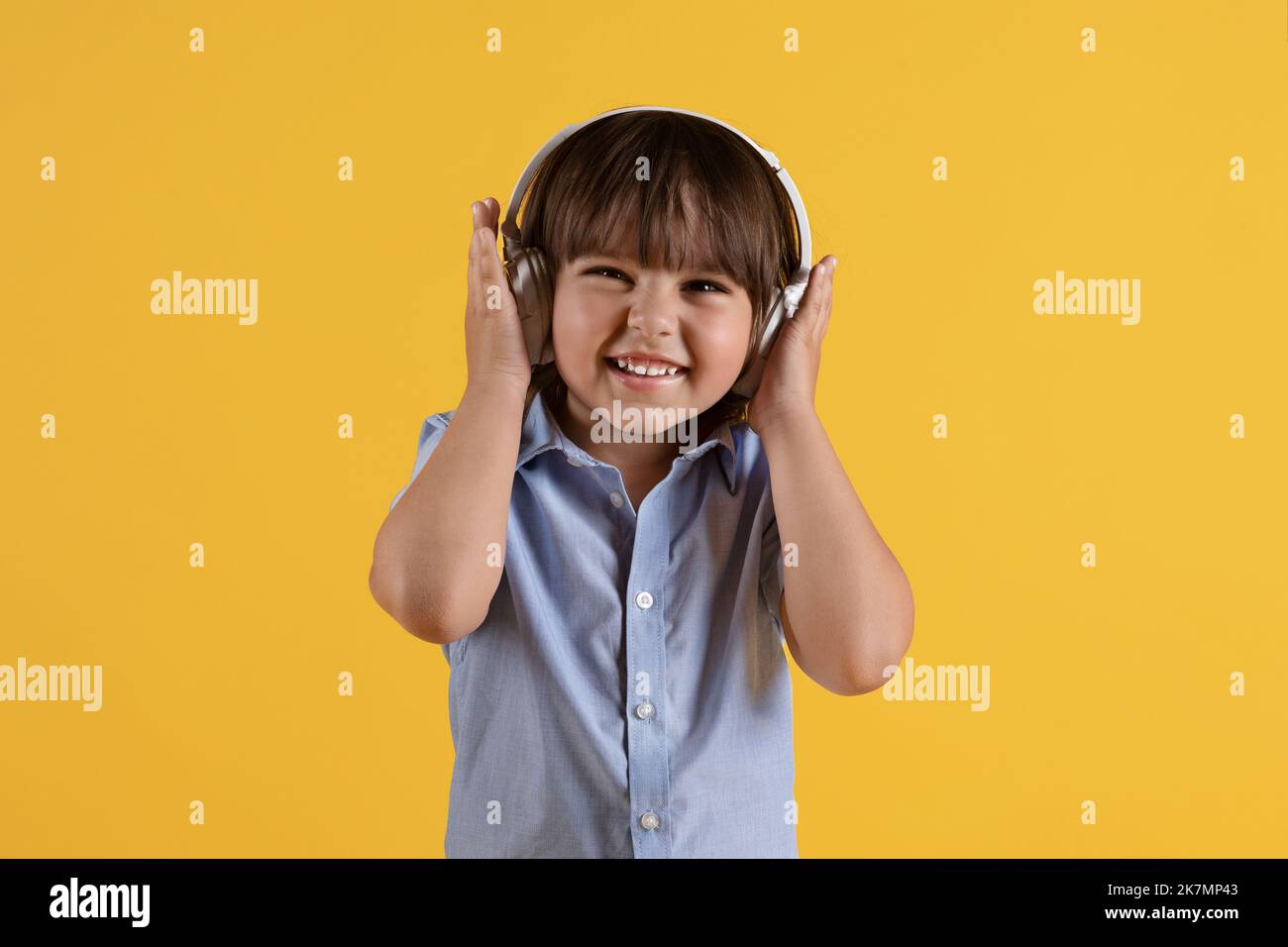 Modern sound technologies. Cute little boy wearing headset listening to ...