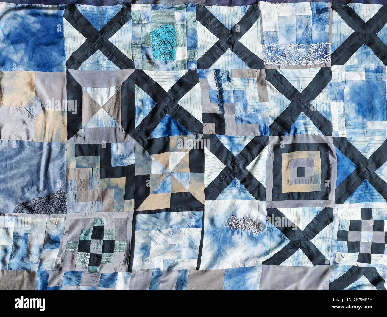 surface of hand-sewn patchwork quilt from pieces of various silk ...