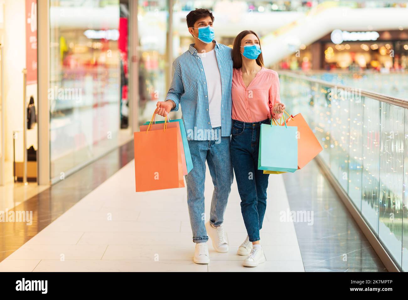 Husband And Wife Shopping Wearing Face Masks Walking In Mall Stock ...