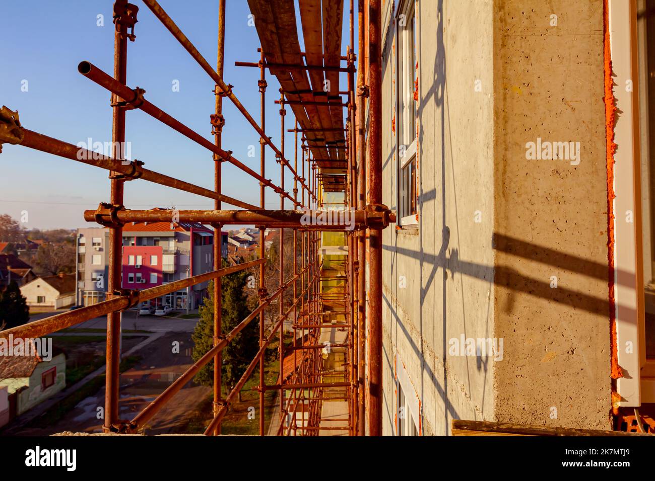 Rusty scaffold placed against unfinished edifice, new residential ...