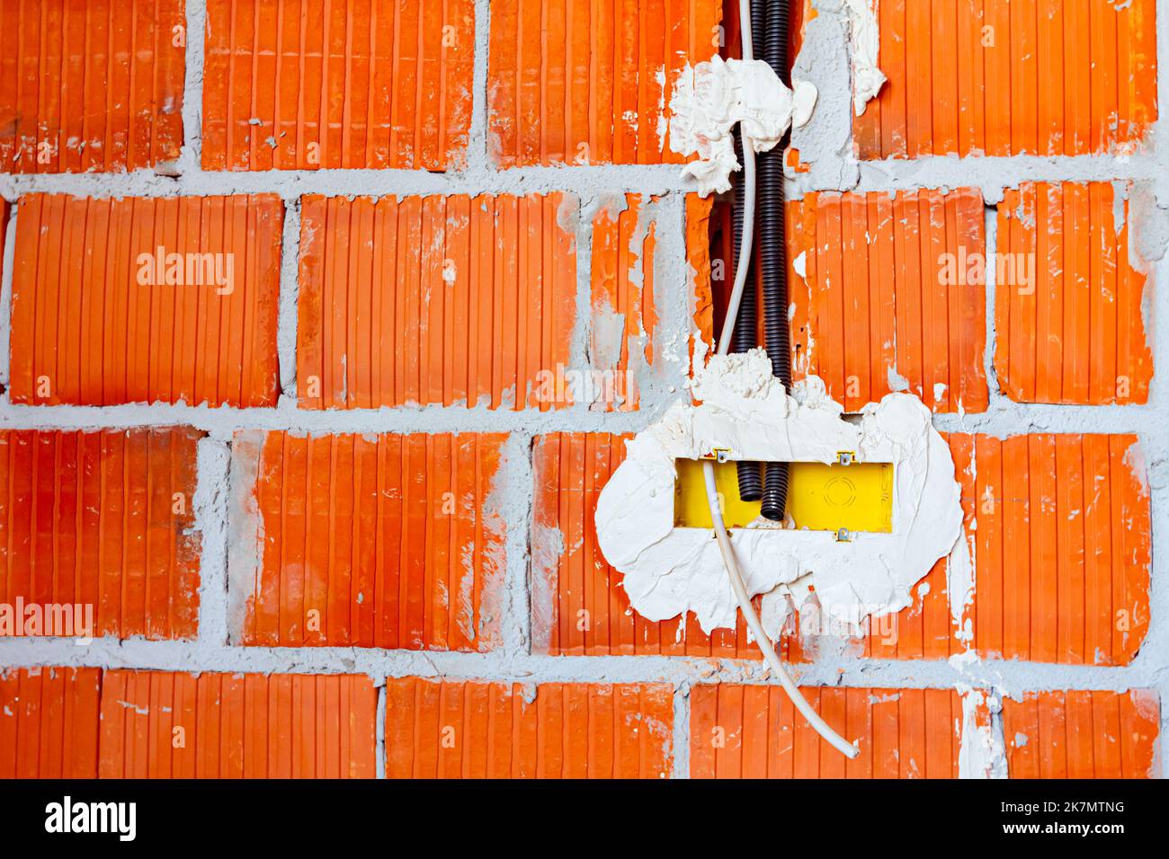Cable and corrugated black pipes are hanging from junction box placed ...